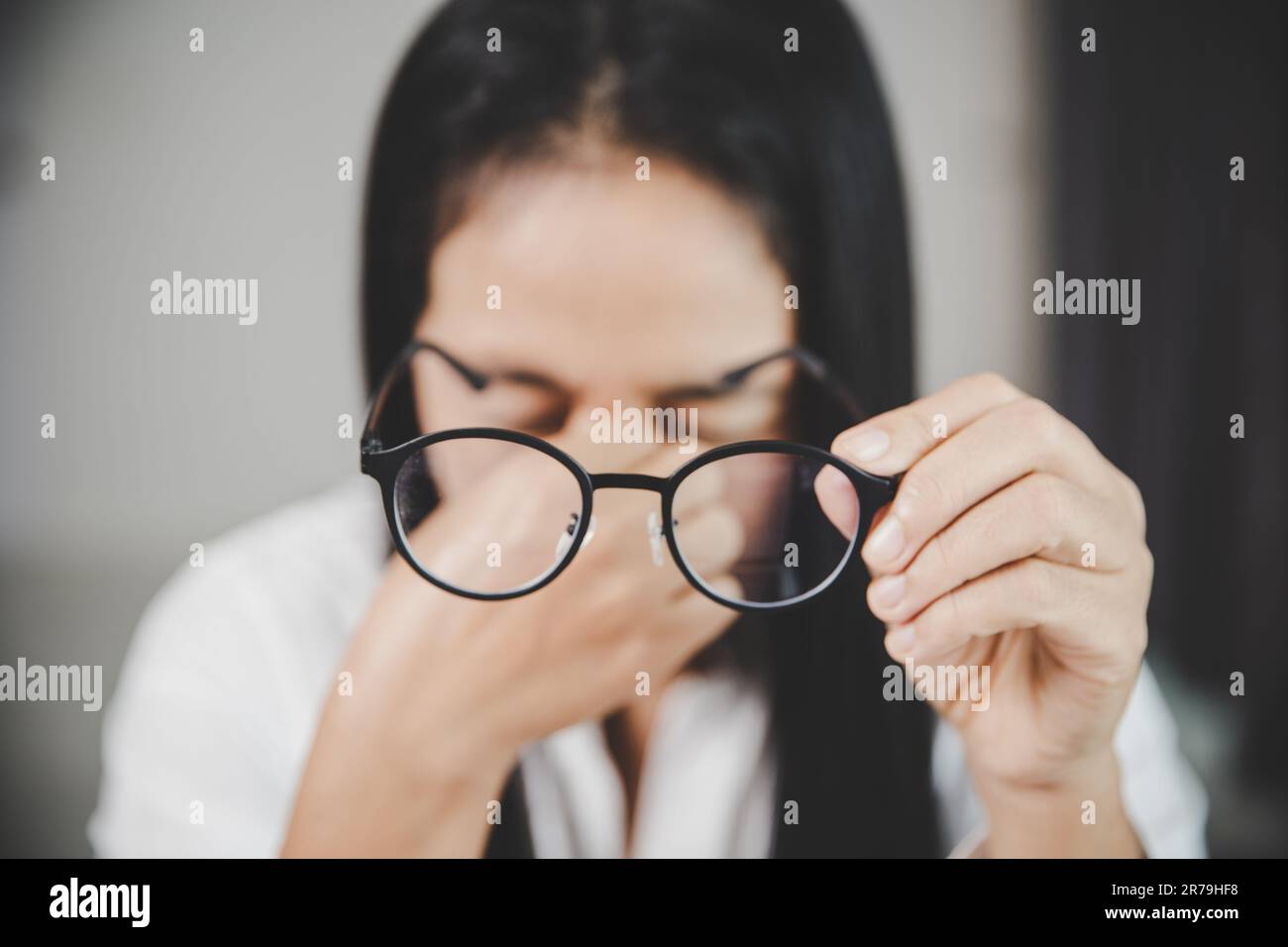 Young business woman person sleepy and has frustration eye problems ...