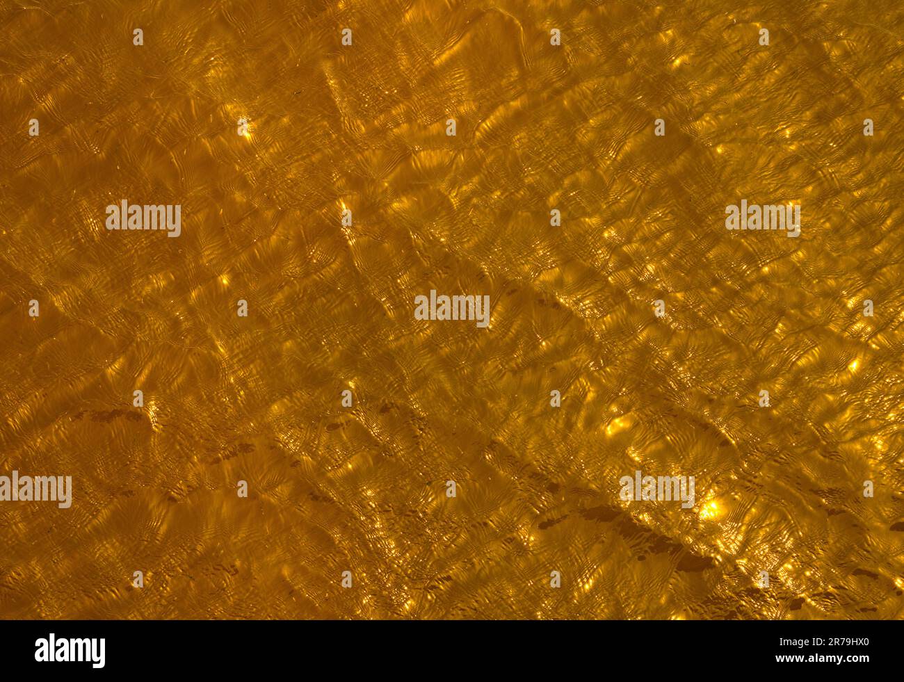 Water of gold color with solar patches of light Stock Photo - Alamy