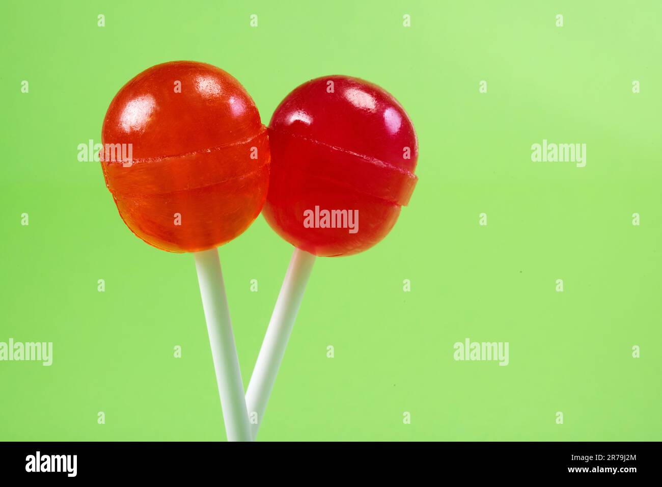 Two lollipops on a stick, a close-up at the green background Stock ...