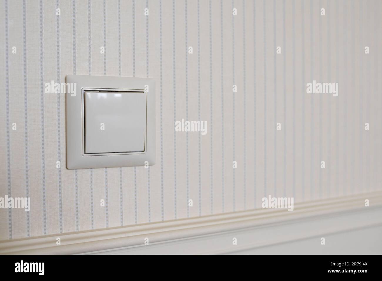 a light switch, a plastic mechanical switch of white color installed on ...