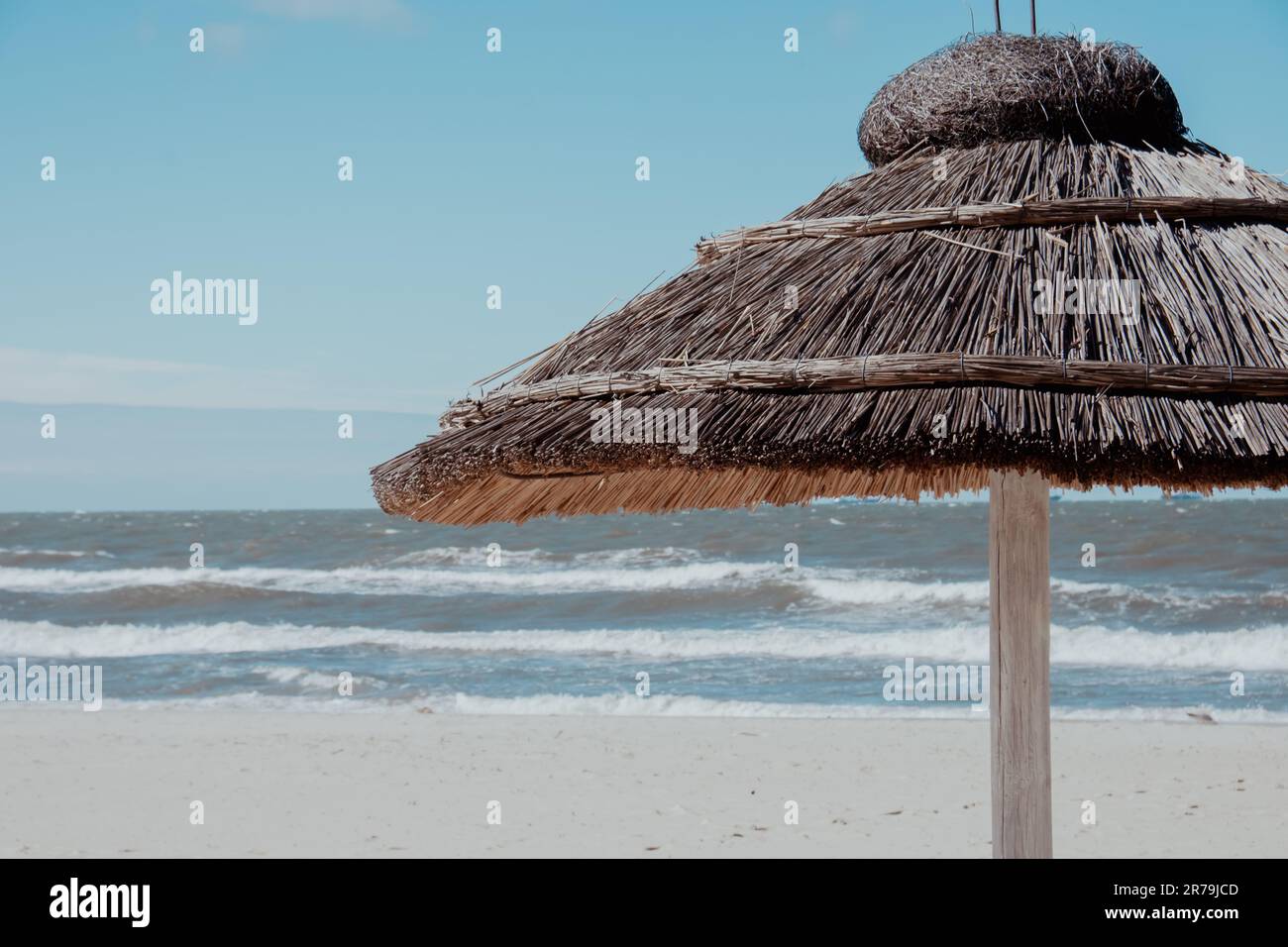 Straw beach rattan parasol at the empty beach with blue sky backgrounds ...