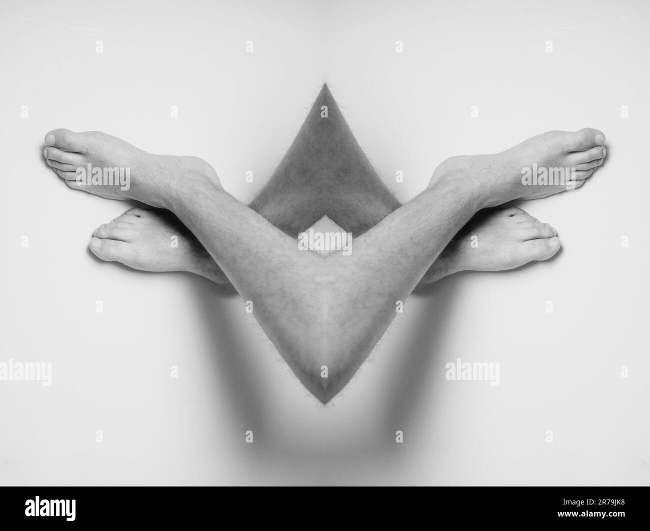 A grayscale of human feet presented in an artistic position crossed in ...