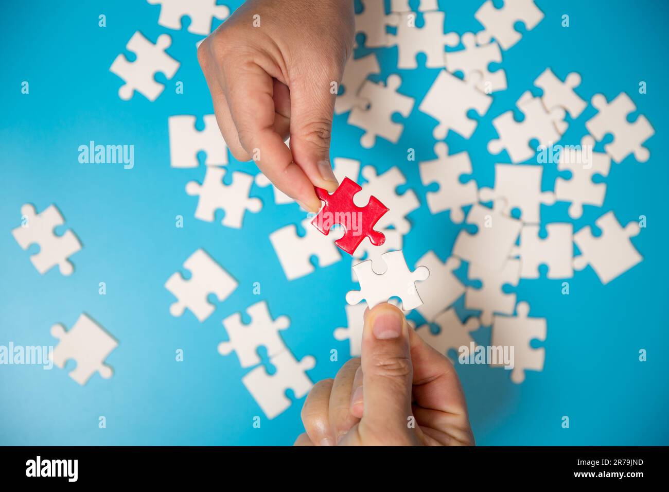 Close up hand holding and playing jigsaw game incomplete. White part of ...