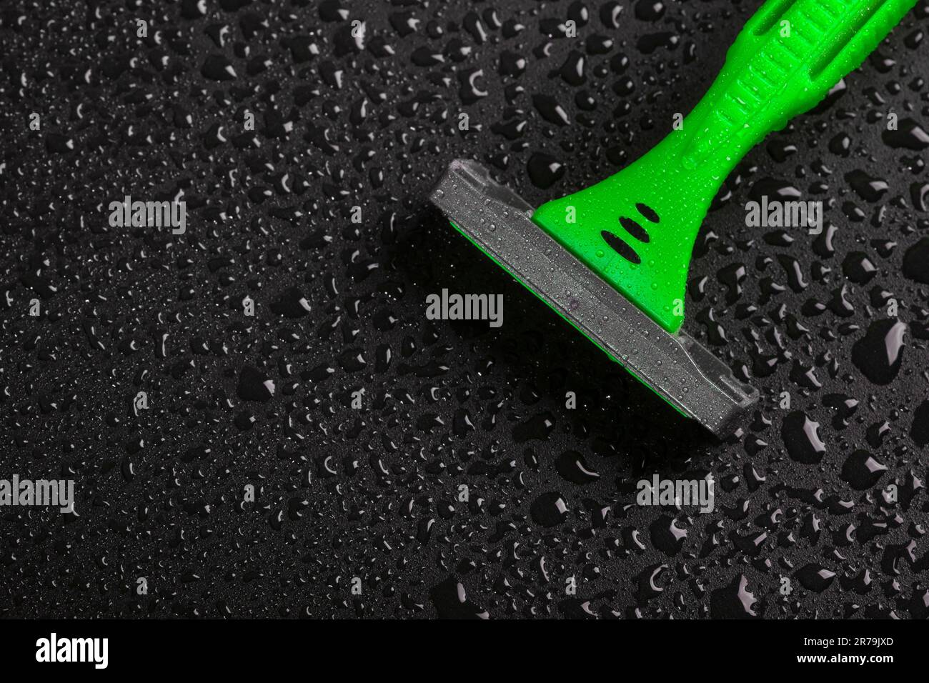 Razor with drops of water on a black background. Top view. Skin care ...