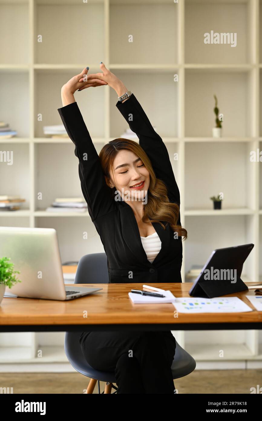 Relaxed office worker woman stretching arms, taking break from work on ...