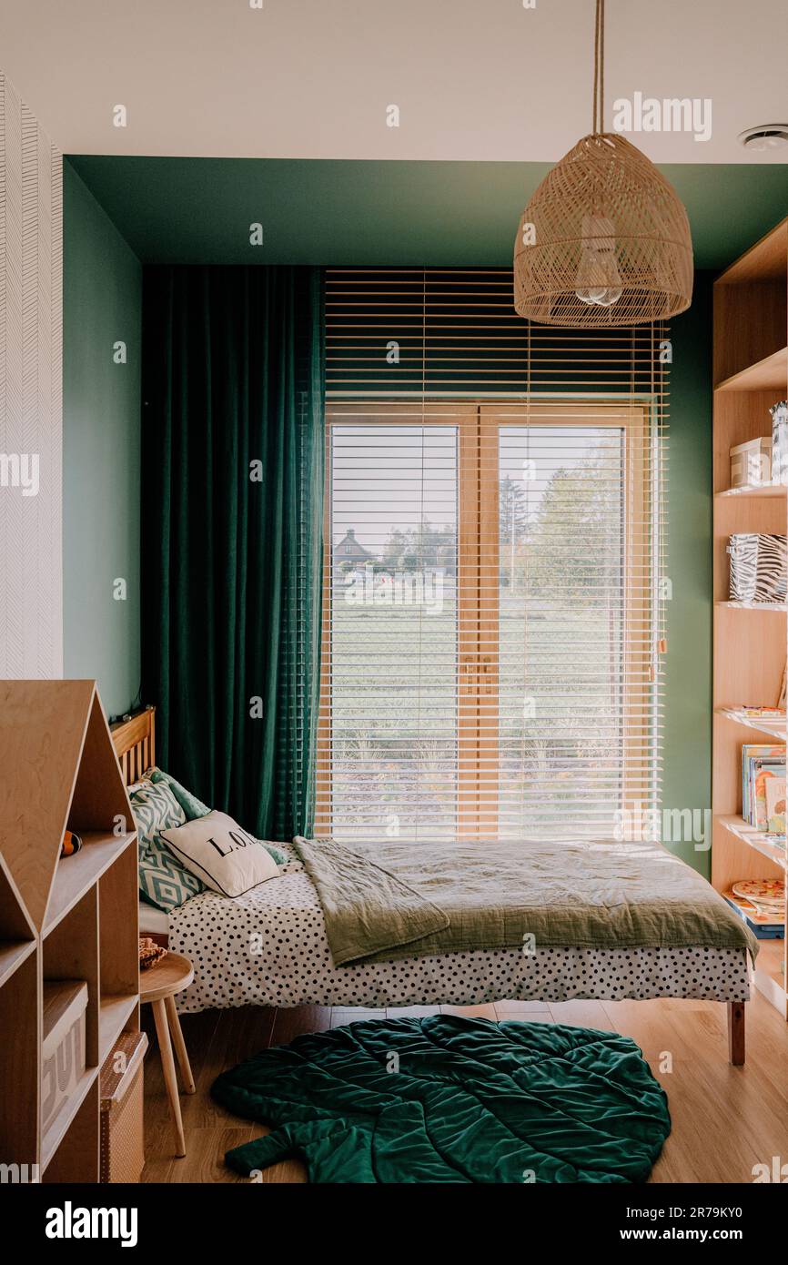 A cozy bedroom with a calm green color palette and wooden accents Stock ...