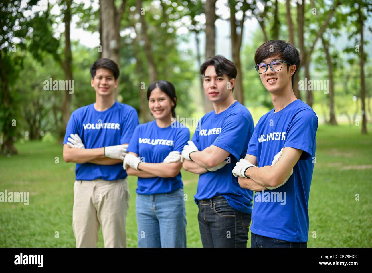 Portrait of confident young volunteers standing in a line at park Stock ...