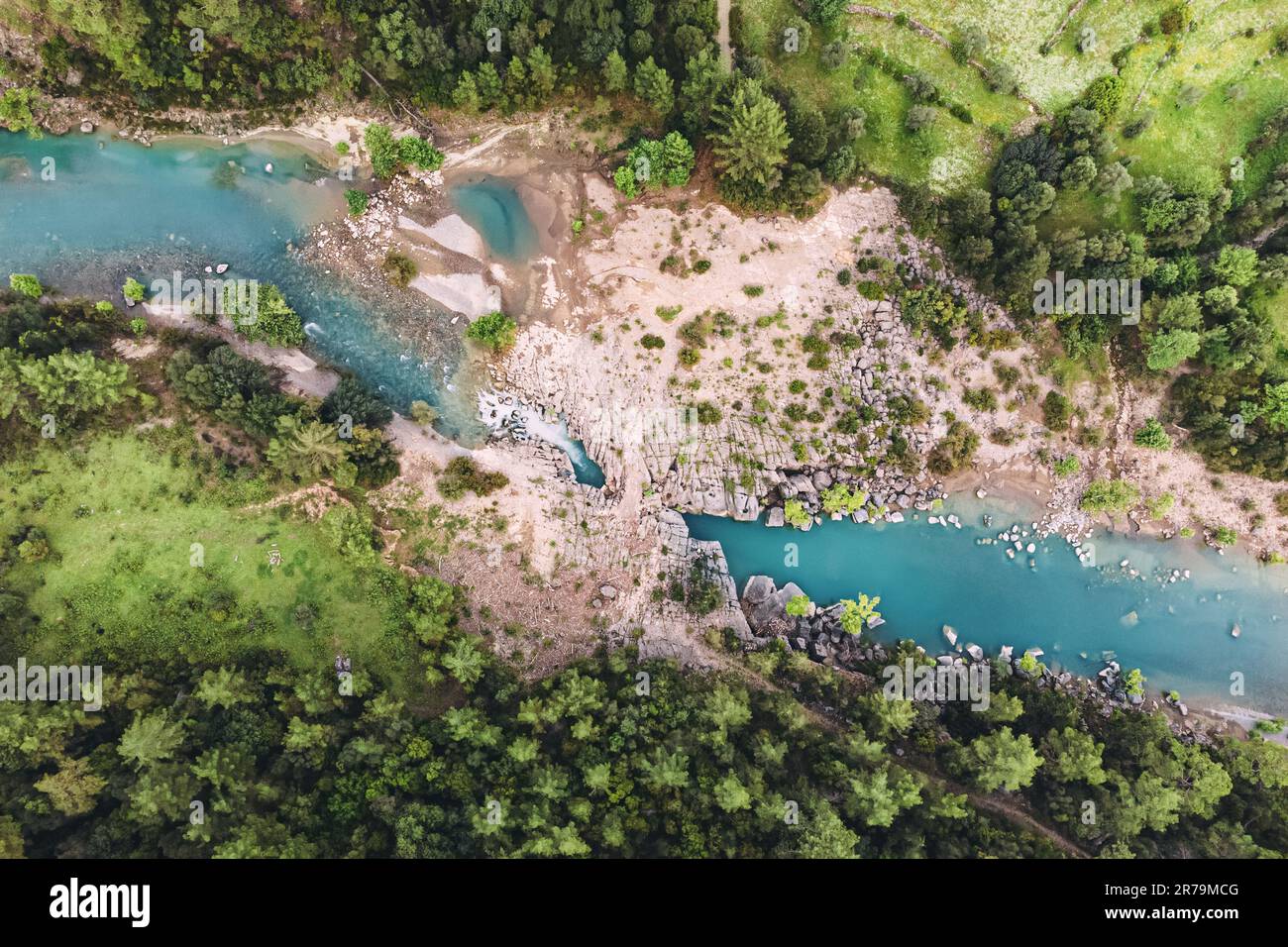 Aerial view of azure blue winding river and bridge in deep canyon ...