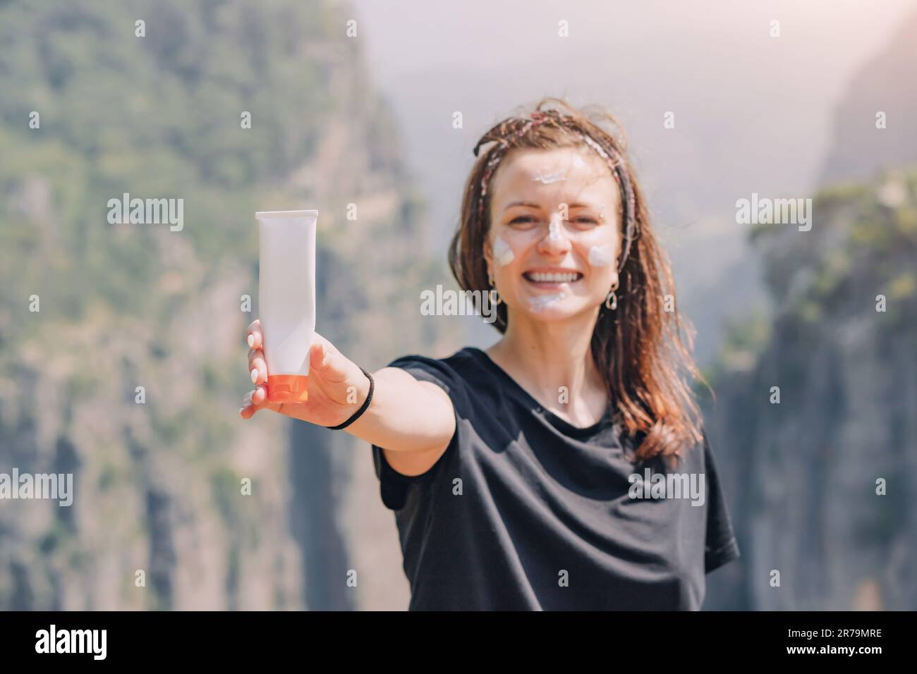Hiker woman applying sun cream to protect her skin from dangerous uv ...