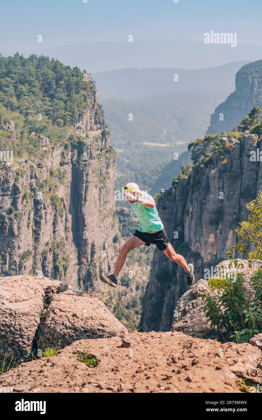 Happy traveler man jumping over the Tazi canyon in Turkey. Tourist ...
