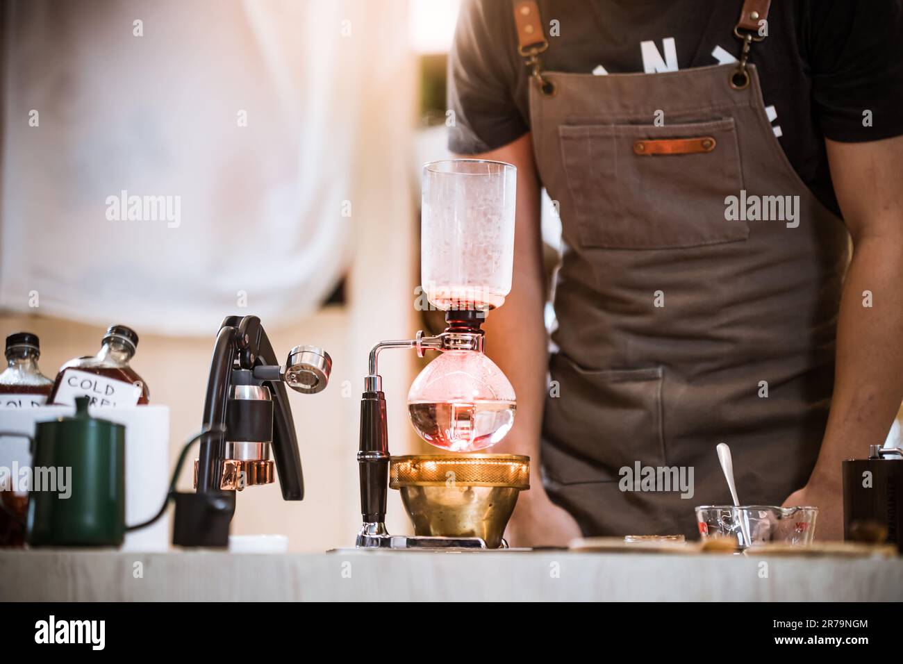 Professional coffee maker - Barista using coffee siphon brewing hot ...