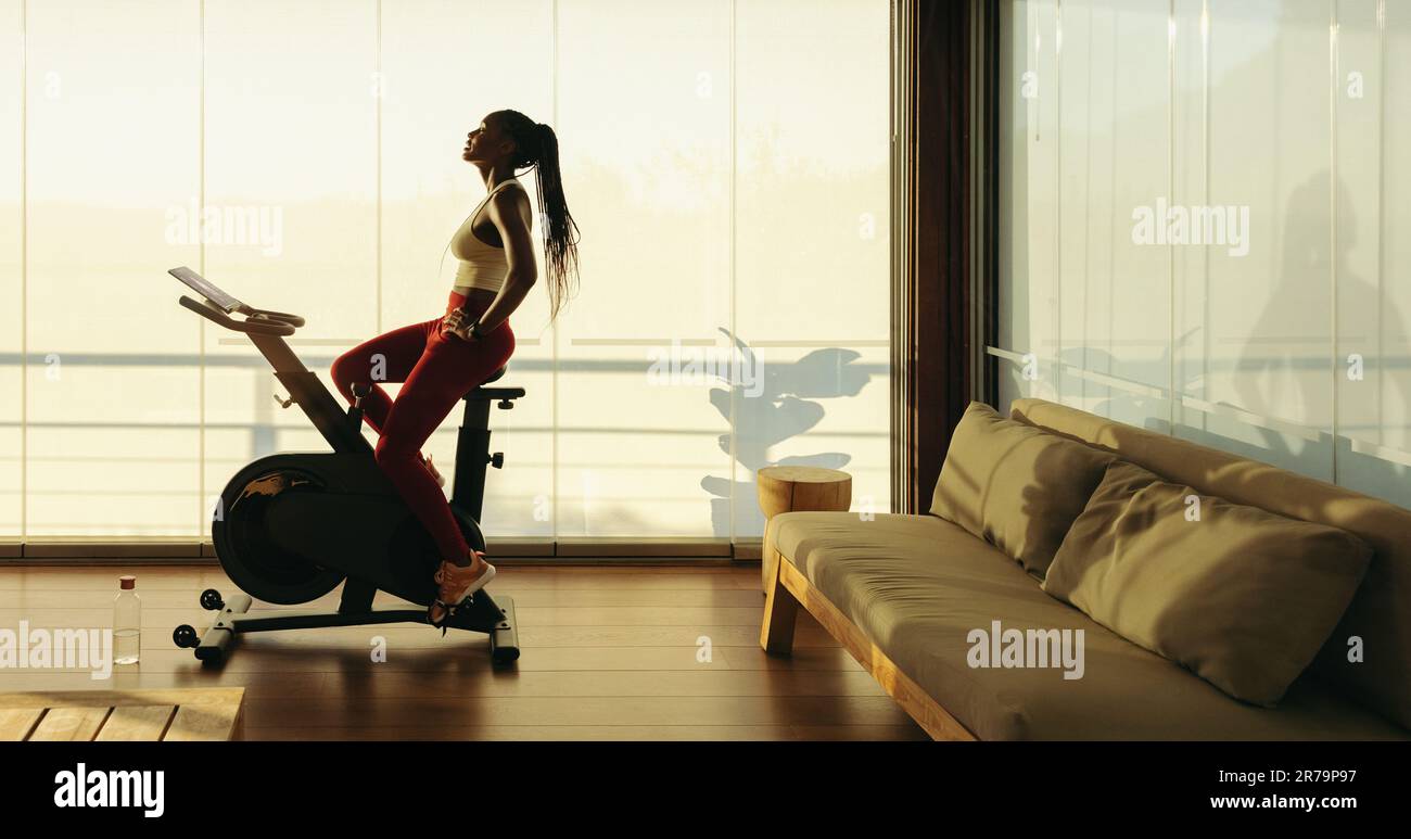 Fit young woman taking a break from a home workout. Woman using a smart ...