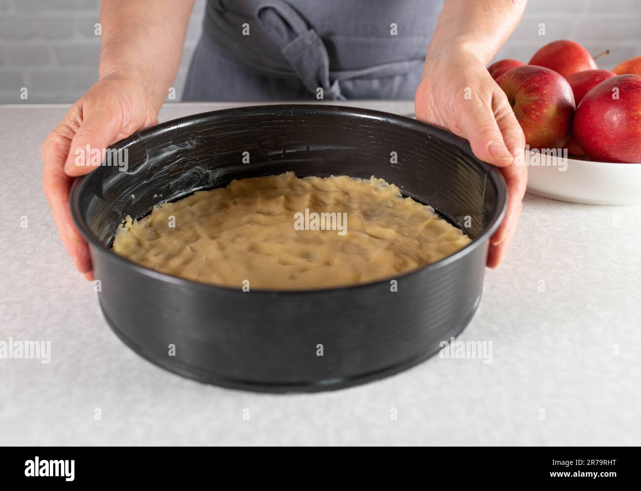 Making apple pie with short crust pastry in a round baking pan. Part of ...