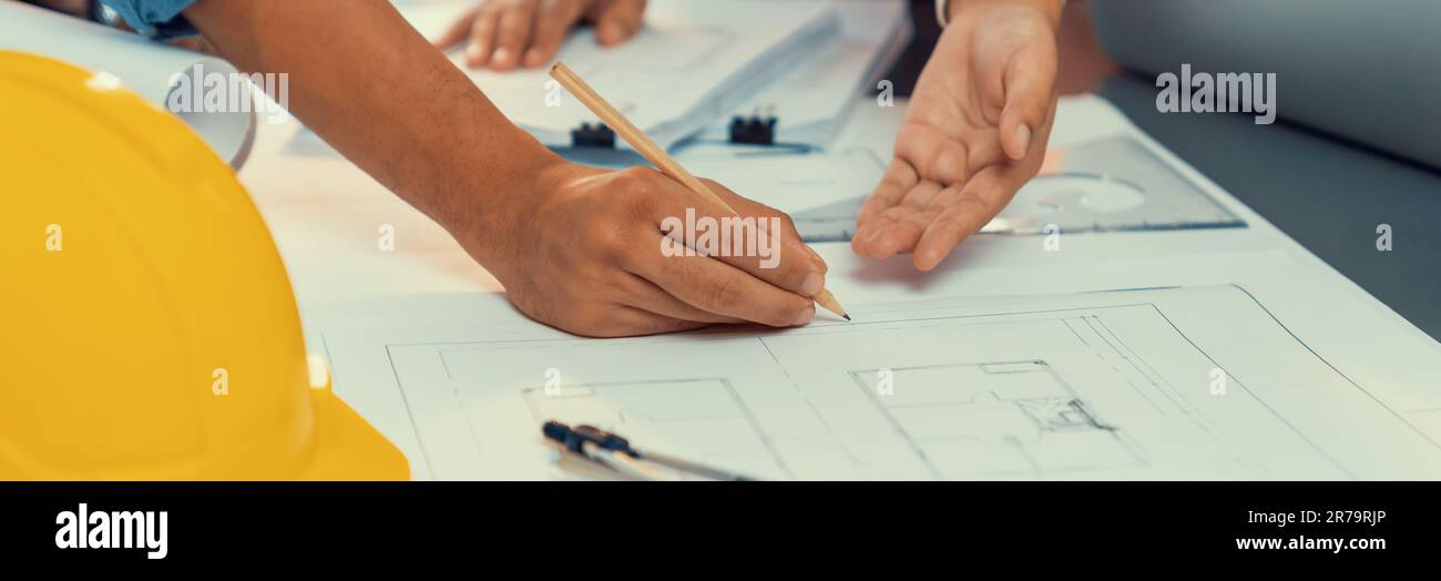 Engineer partner drawing and working on blueprint design together on ...