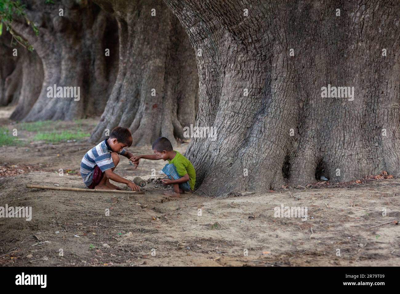 Two children playing under big trees, Amarapura (near Mandalay ...