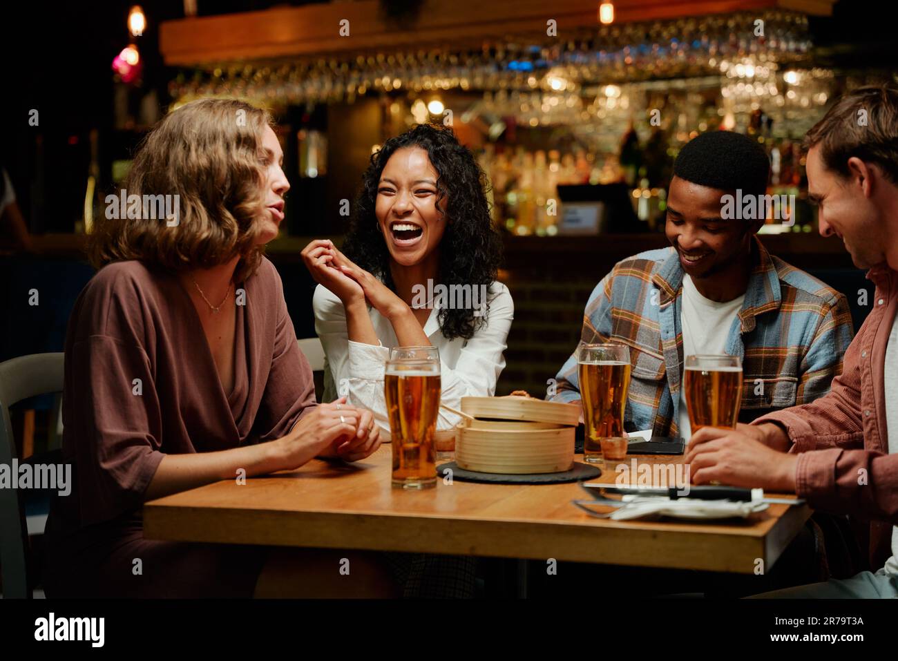 Happy young multiracial group of friends in casual clothing talking and ...