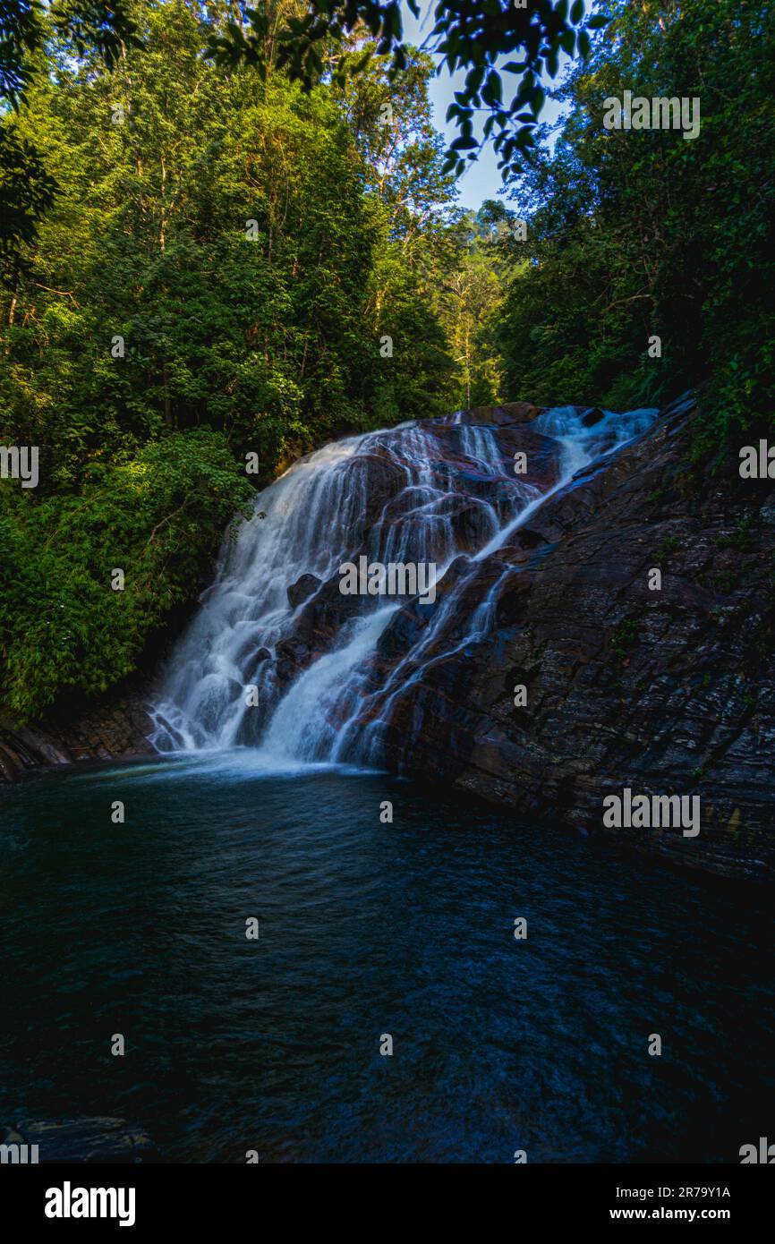 A scenic landscape featuring a waterfall cascading down a rocky terrain ...