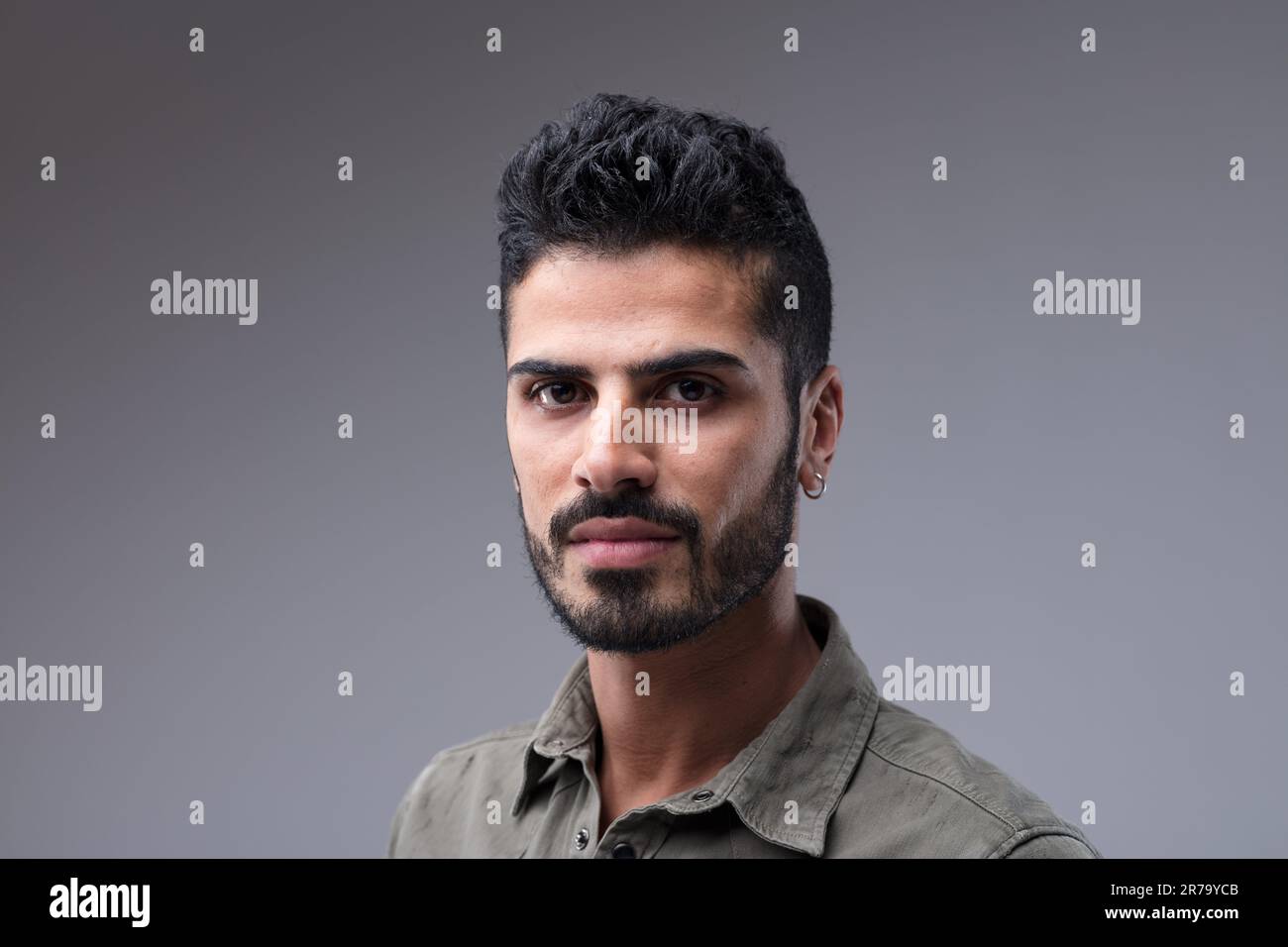 Fit Middle Eastern male, subtly smiling in a close-up portrait. His ...