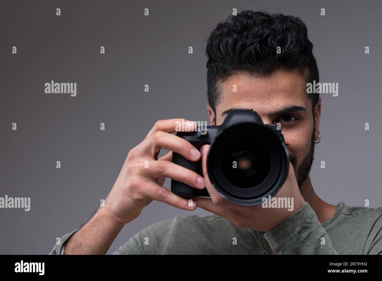 Neat, slim man in green, an ardent photographer. Wielding a DSLR with a ...