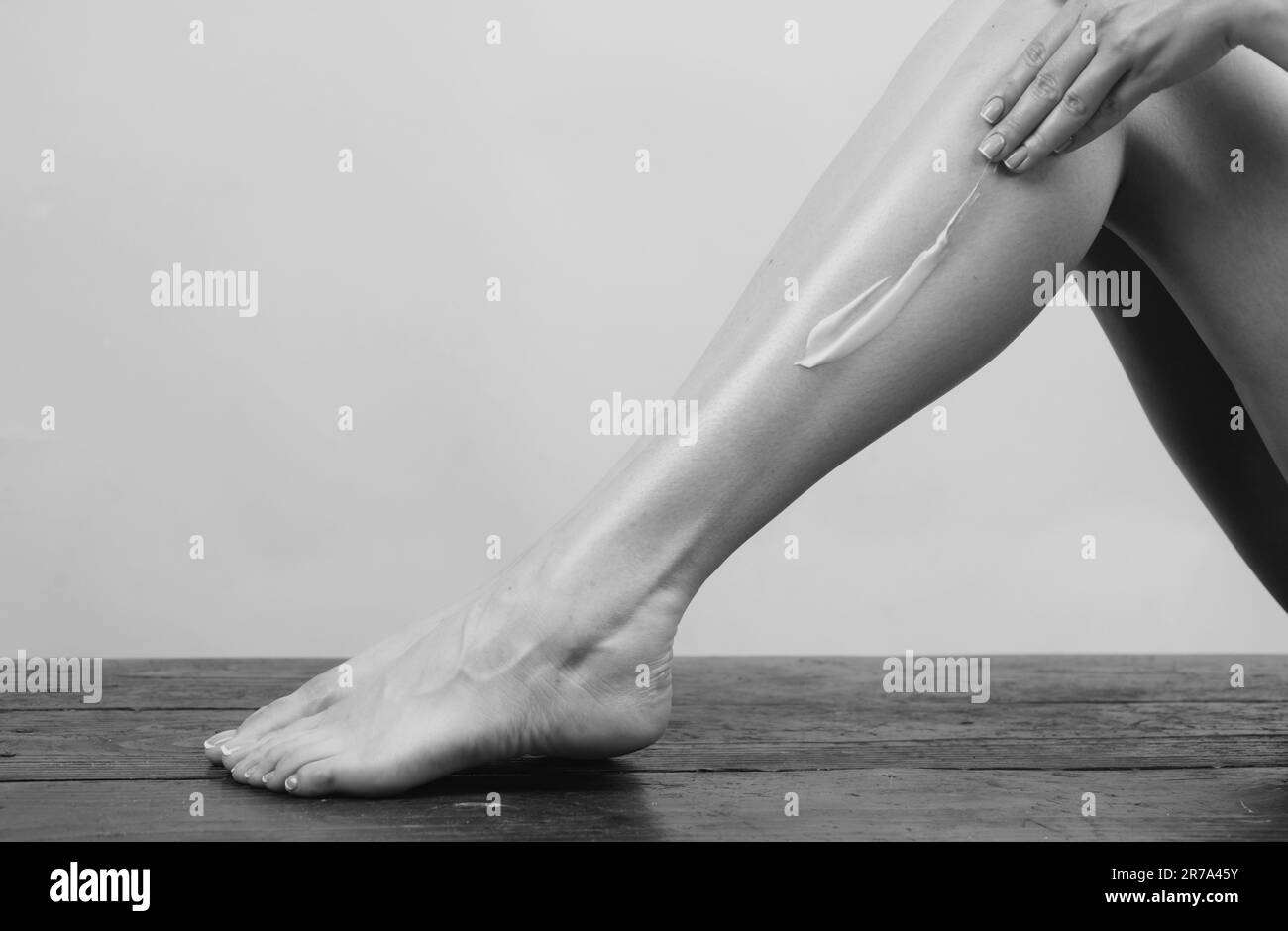 Woman applying moisturiser legs Black and White Stock Photos & Images ...