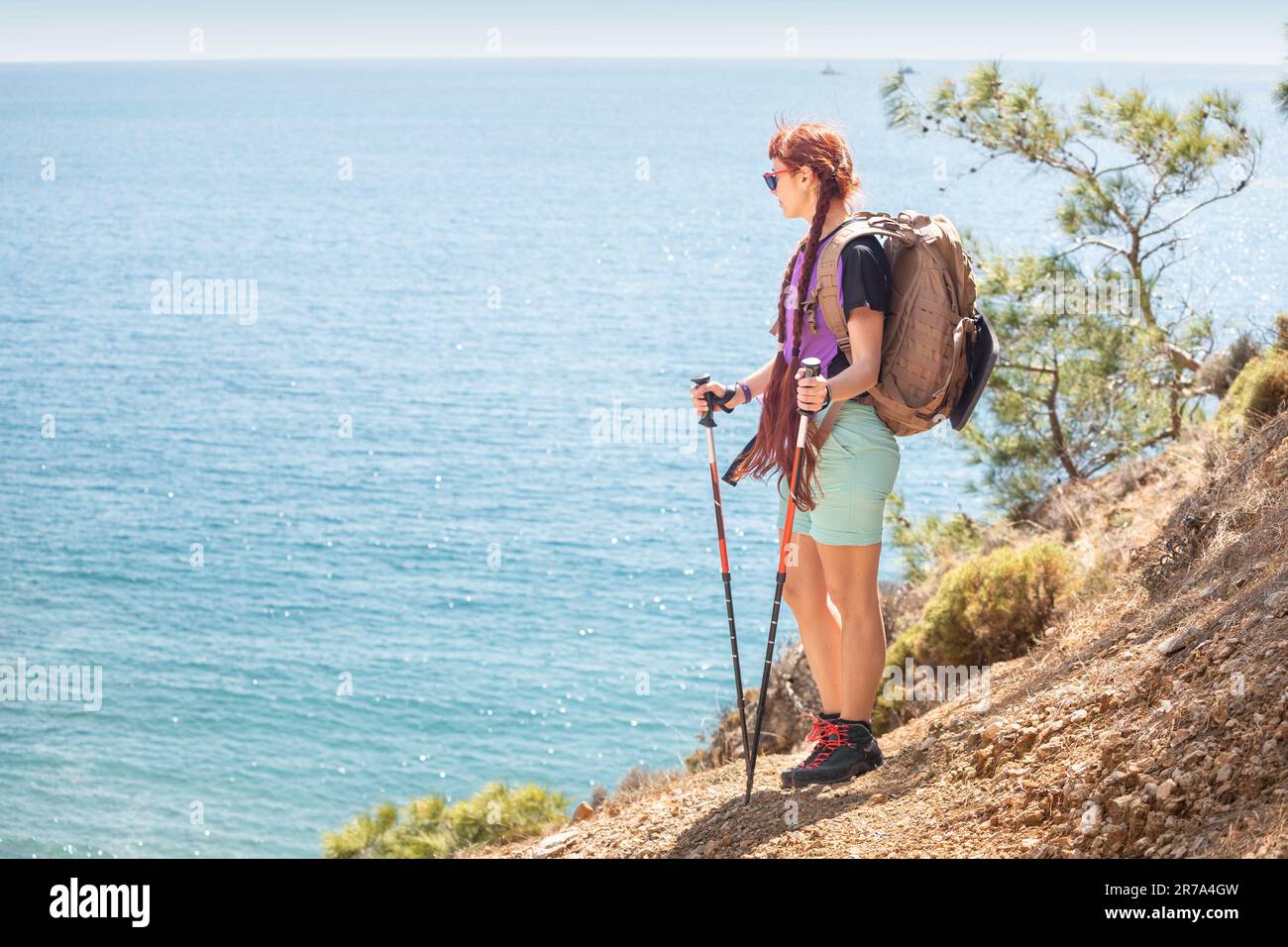 Happy redhead hiker girl with trekking poles walking by scenic Lycian ...