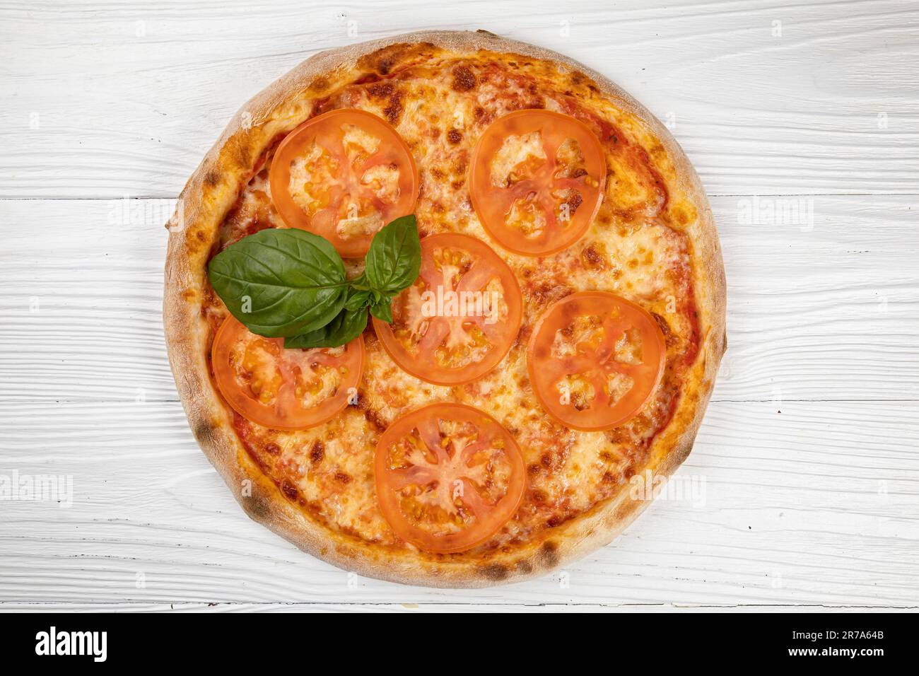 A delicious looking small pizza with a thin crust topped with fresh ...