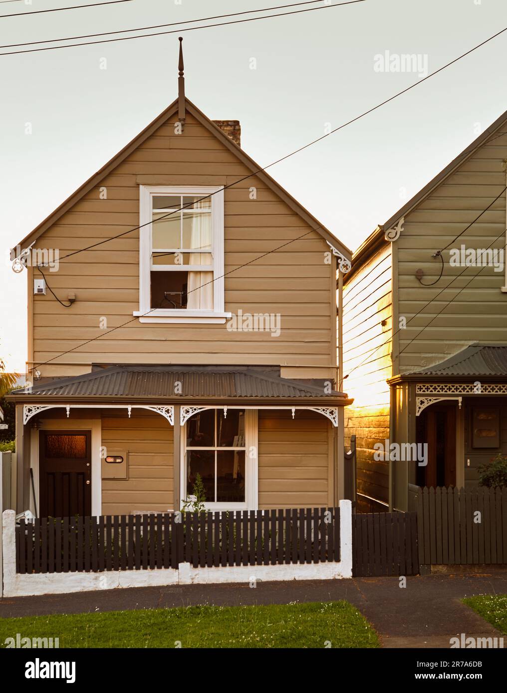 An idyllic two-story building with white window frames and a pristine ...