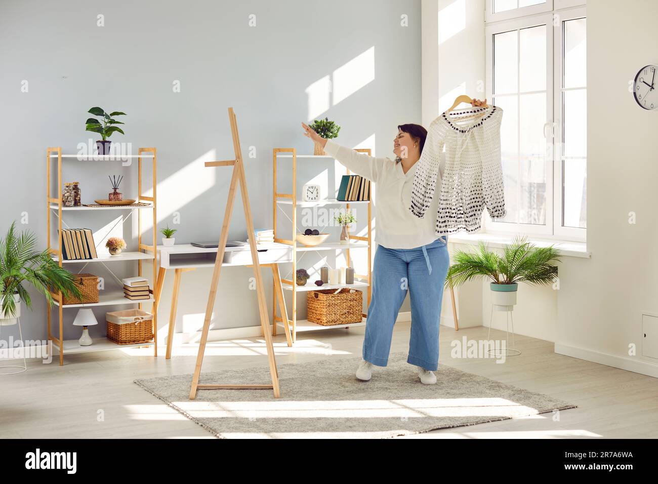 Happy, confident fat woman choosing what to wear, looking in mirror ...