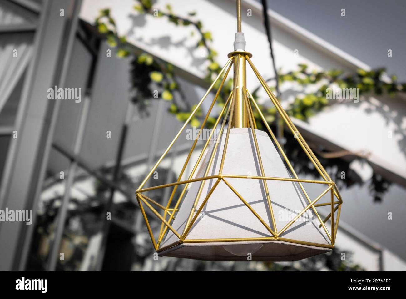Designer garden pendant lamp hanging on the summer terrace during the ...