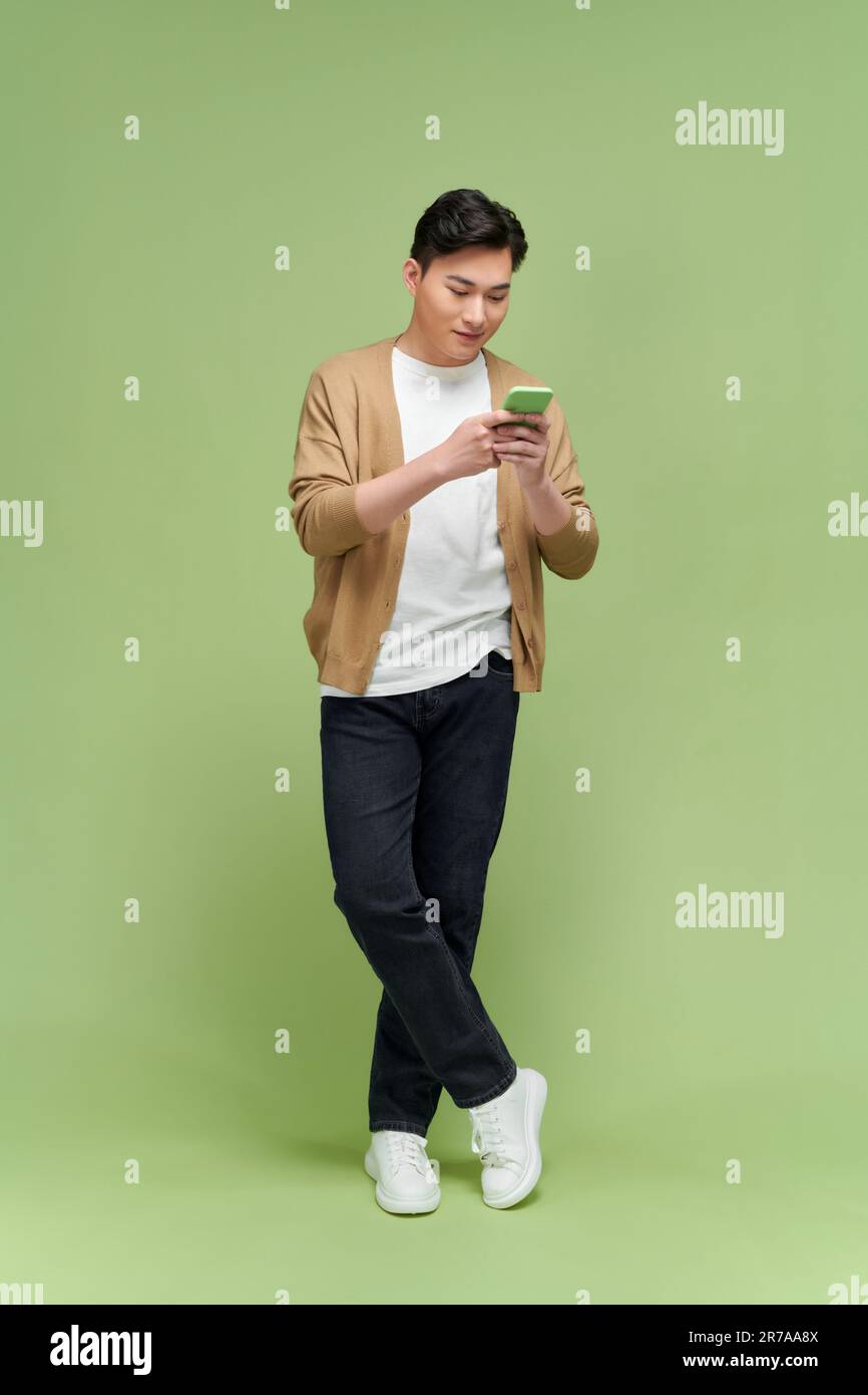 Happy asian young man using smart phone cellphone for calls Stock Photo ...