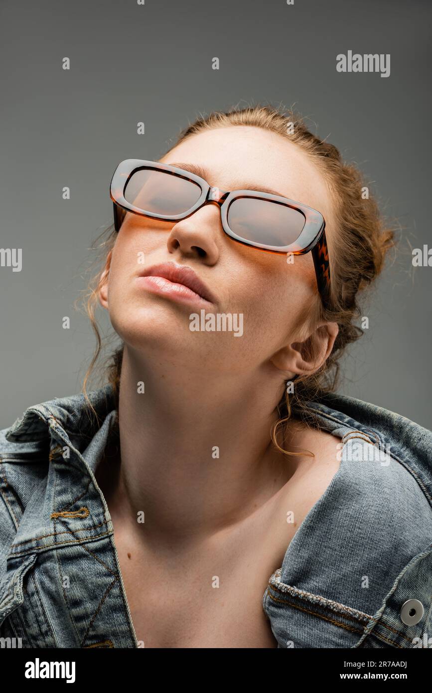 Portrait of red haired and freckled young woman in stylish sunglasses ...