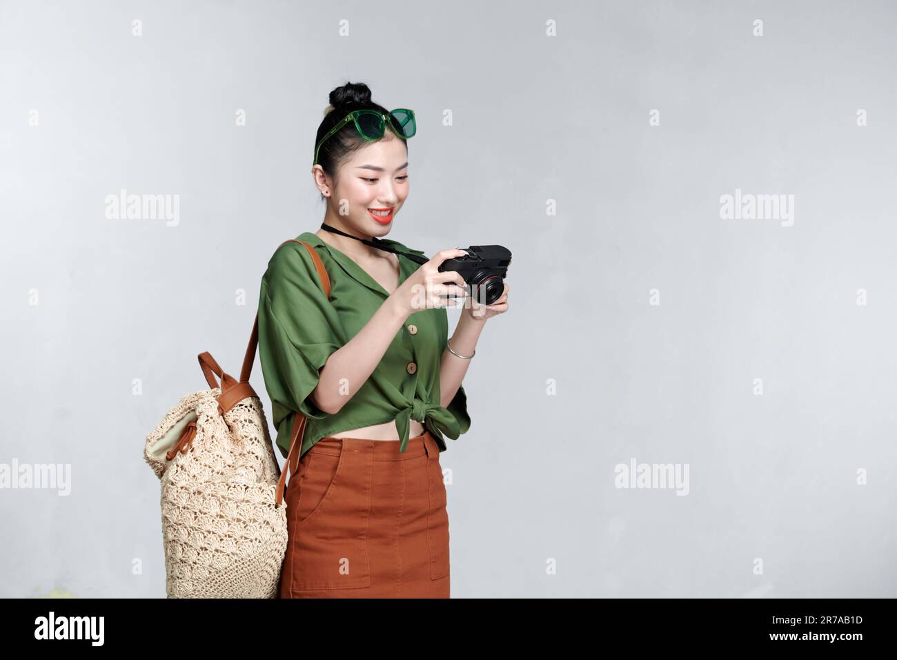 attractive energetic Asian woman happily holding camera isolated on ...