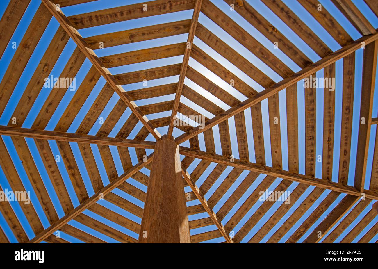 Large wooden pagoda frame structure outside against blue sky background ...