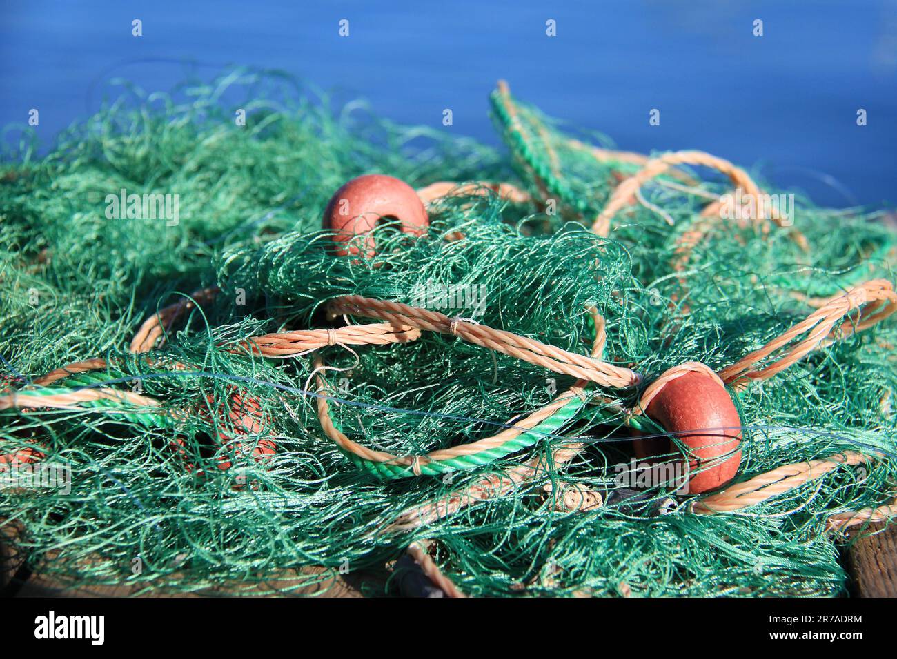 A green fishing net with the blue sea in the background Stock Photo - Alamy