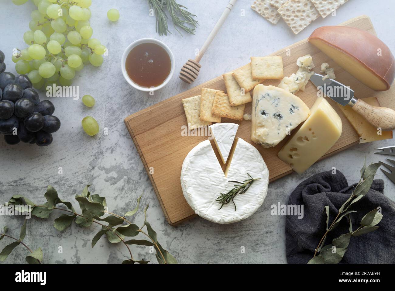 A rustic wooden table displaying an array of cheeses and fresh, juicy ...