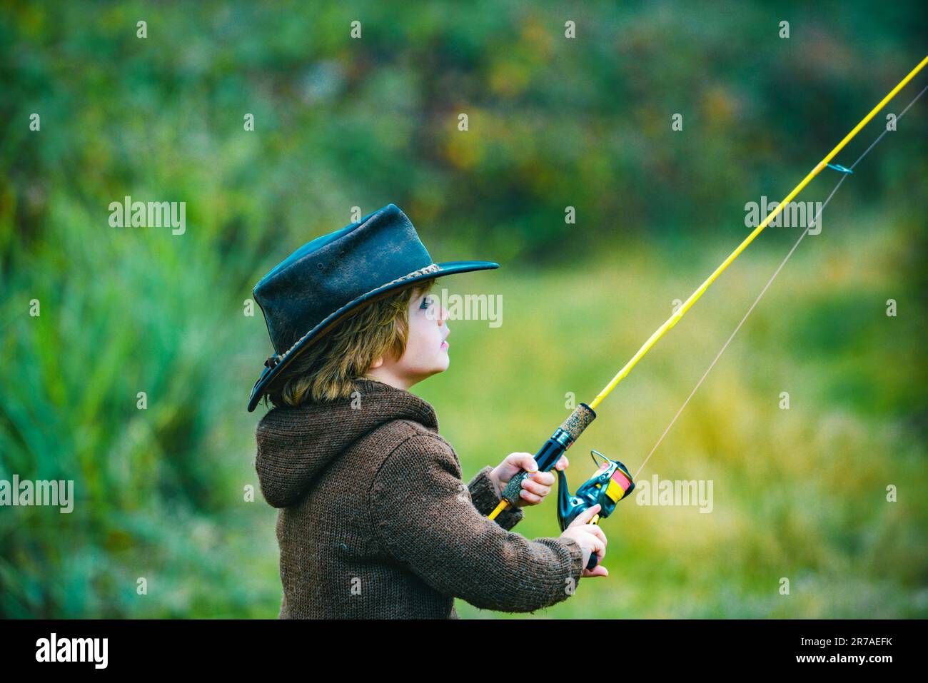 Kid with fishing rod at lake. Little boy catching a fish. Lonely happy ...
