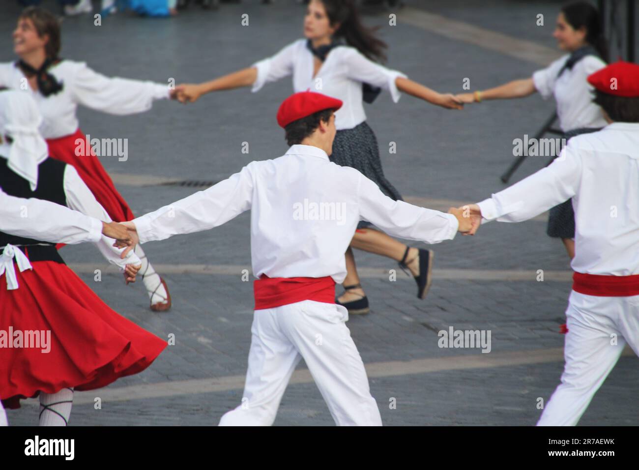 A group of happy children wearing red hats are doing a fun, energetic ...