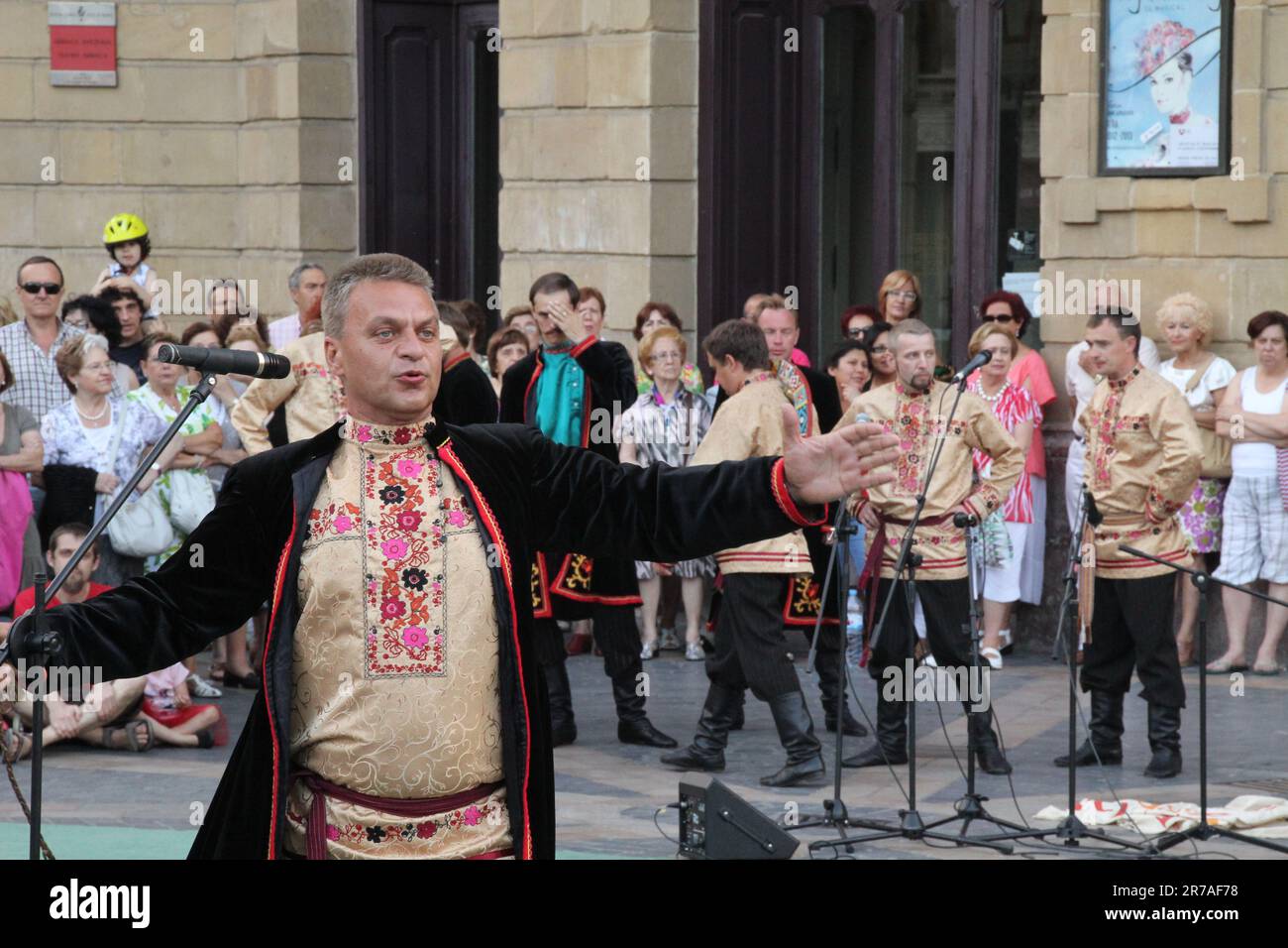 A group of people is watching a performance onstage, with other ...