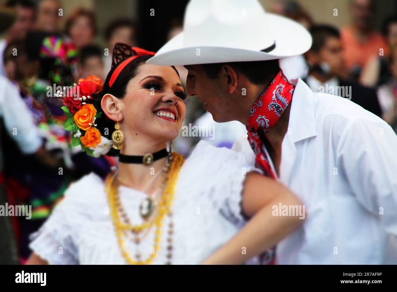 Two people, dressed in colorful clothing, are happily dancing in the ...