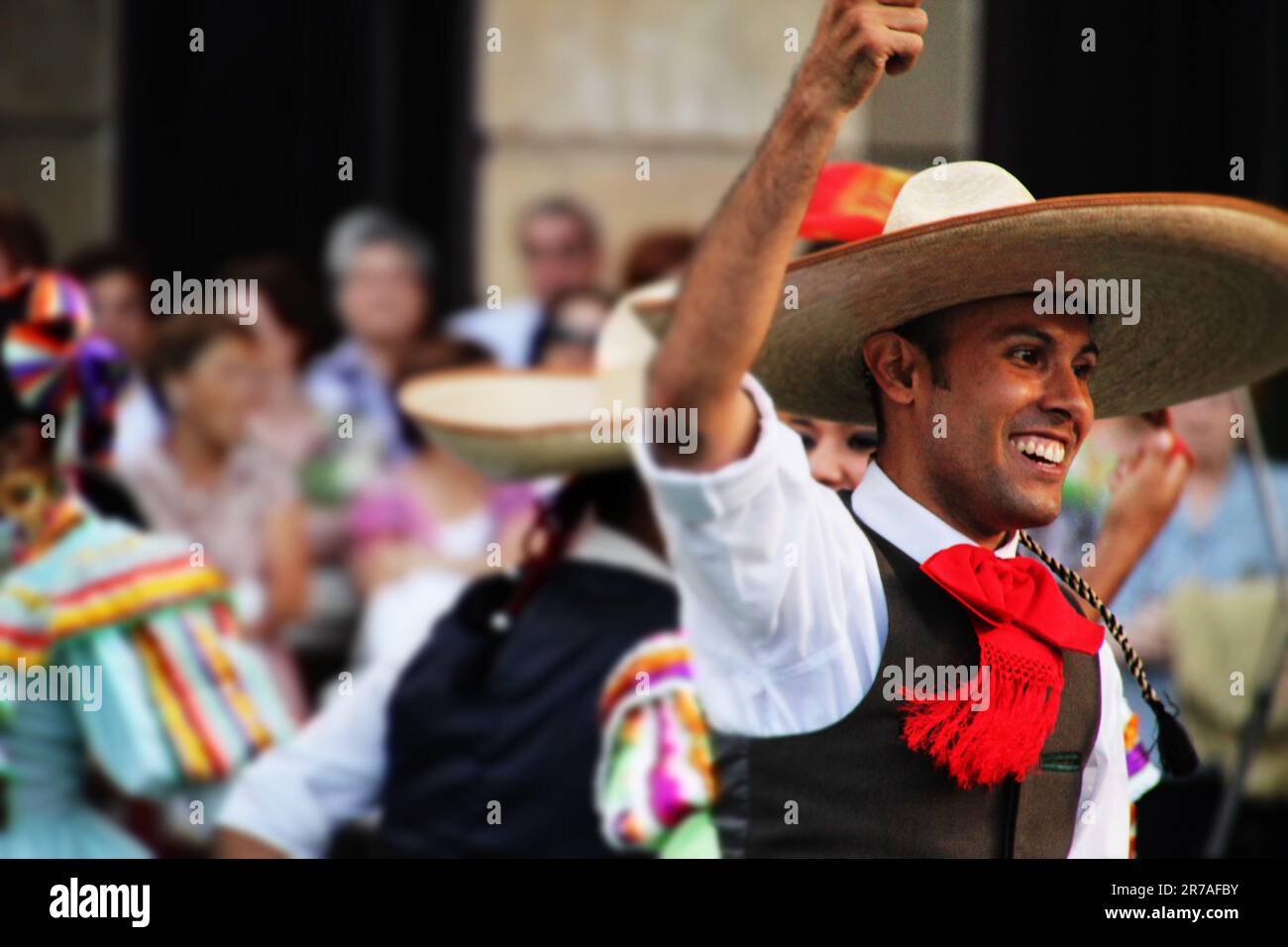 A diverse group of people wearing colorful costumes and hats are ...