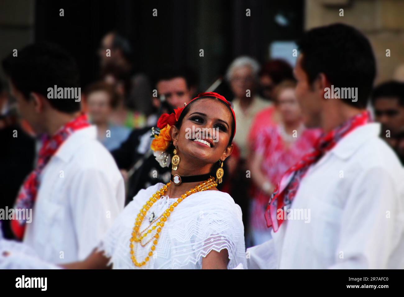 Two people standing side by side wearing costumes with red ribbons ...