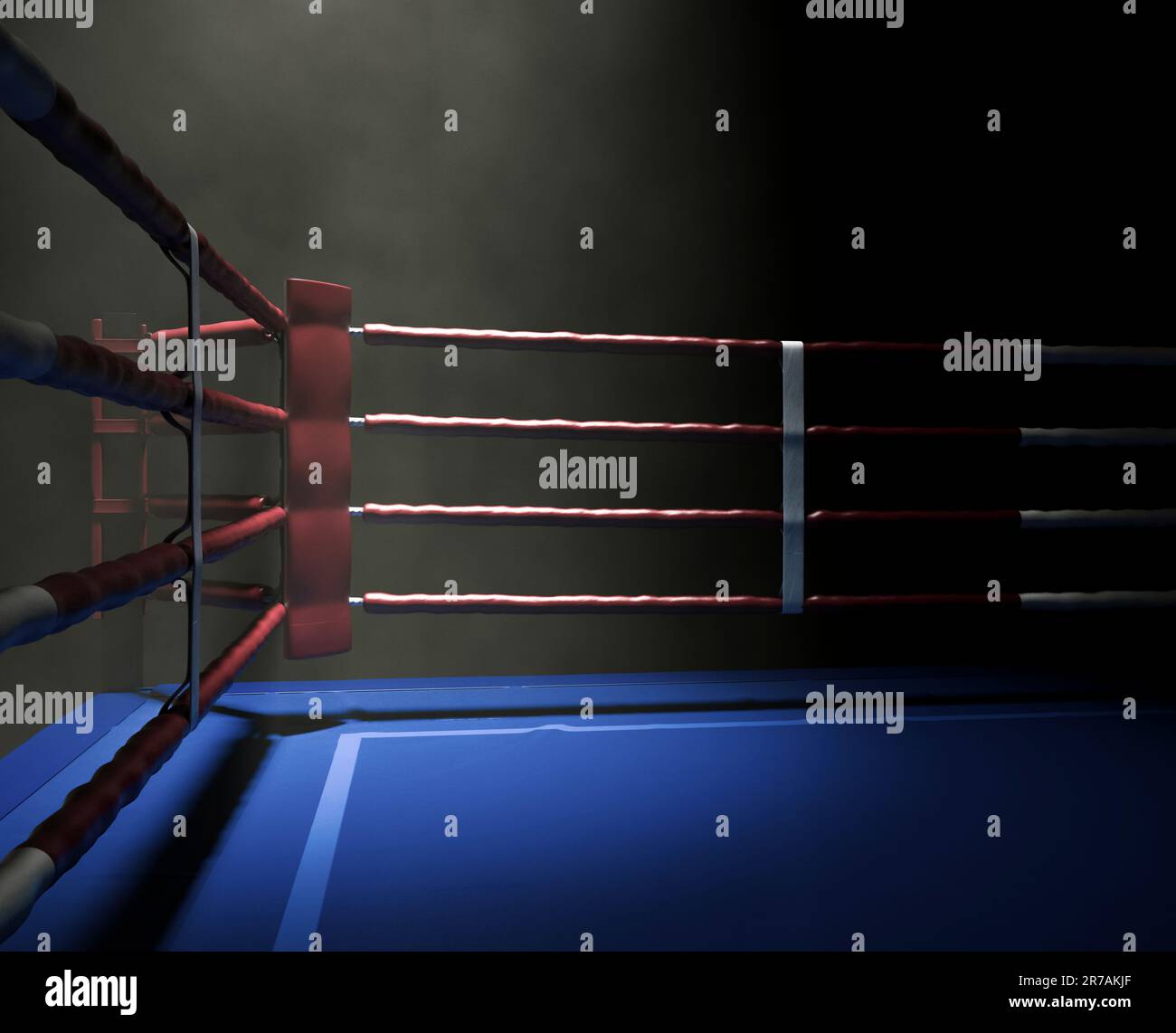 A dimly spotlit corner of a boxing ring surrounded by ropes on a dark ...
