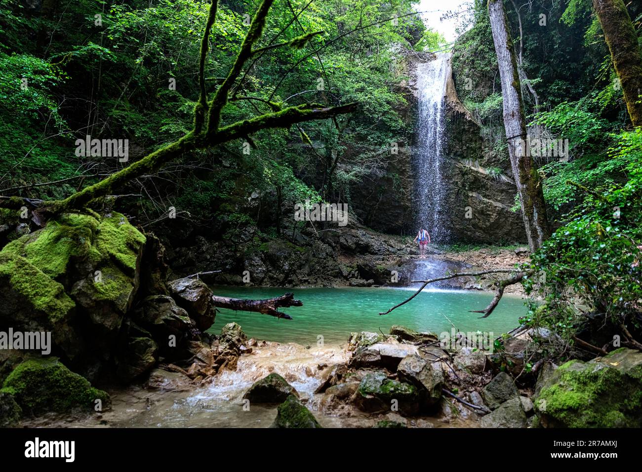 Man tourist at a Beautiful and picturesque Butori waterfall surrounded ...