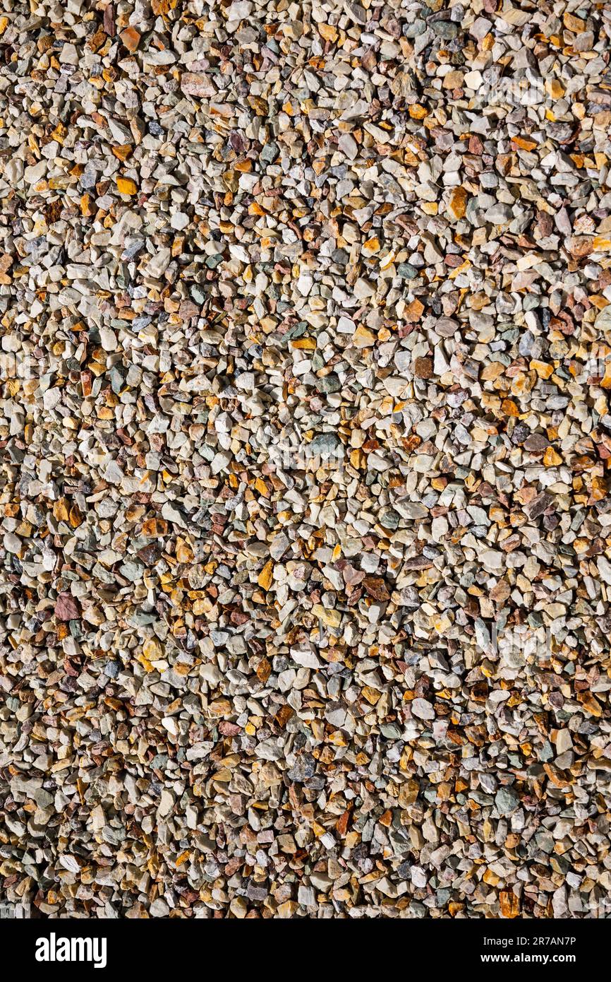 A close-up of a gravel surface with small, angular stones scattered ...