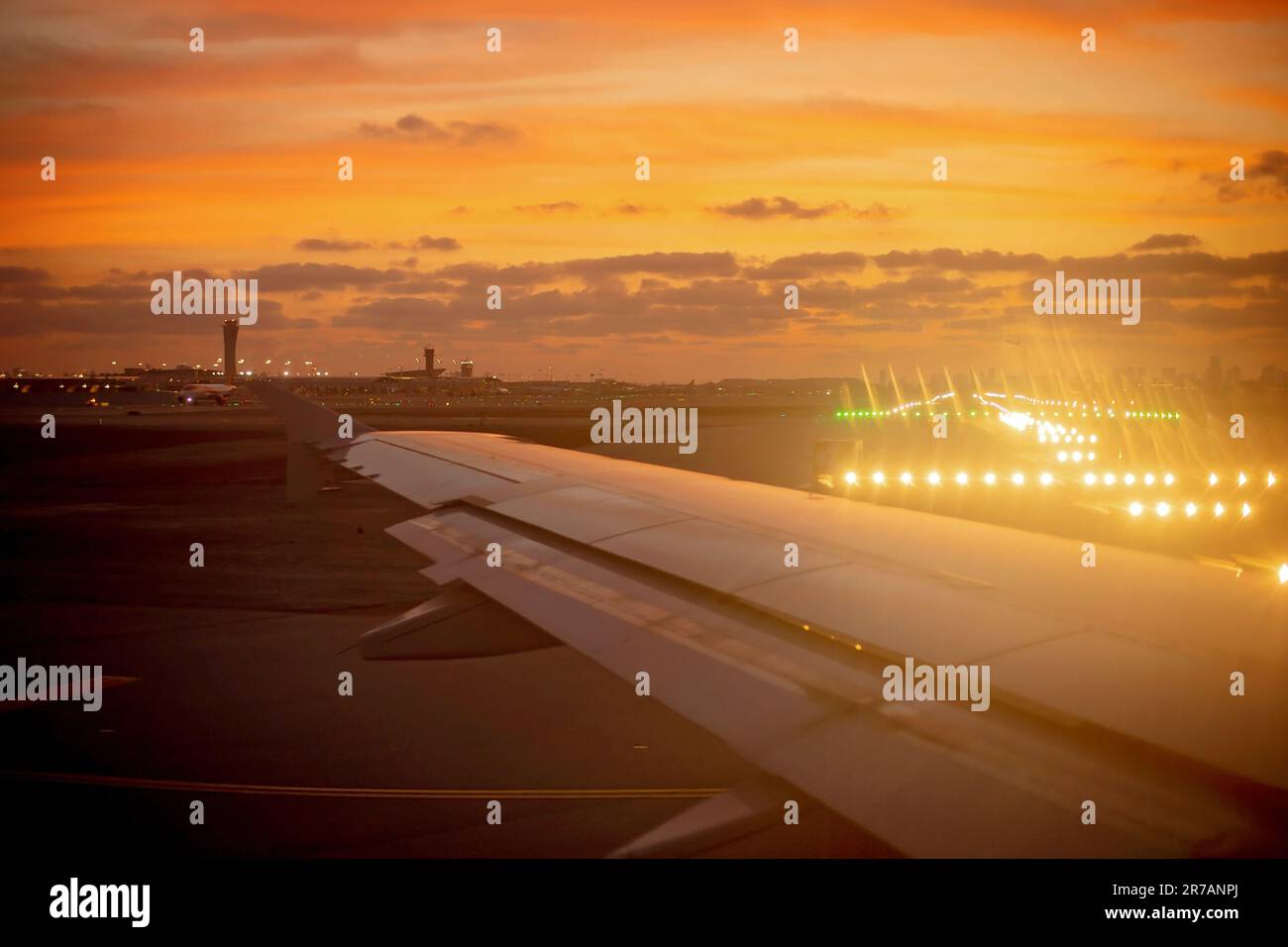 Beautiful sunset over the airport from a plane window on taking off ...