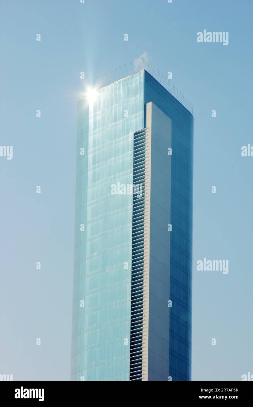 High-rise building with blue glass facade against the blue sky. Multi ...