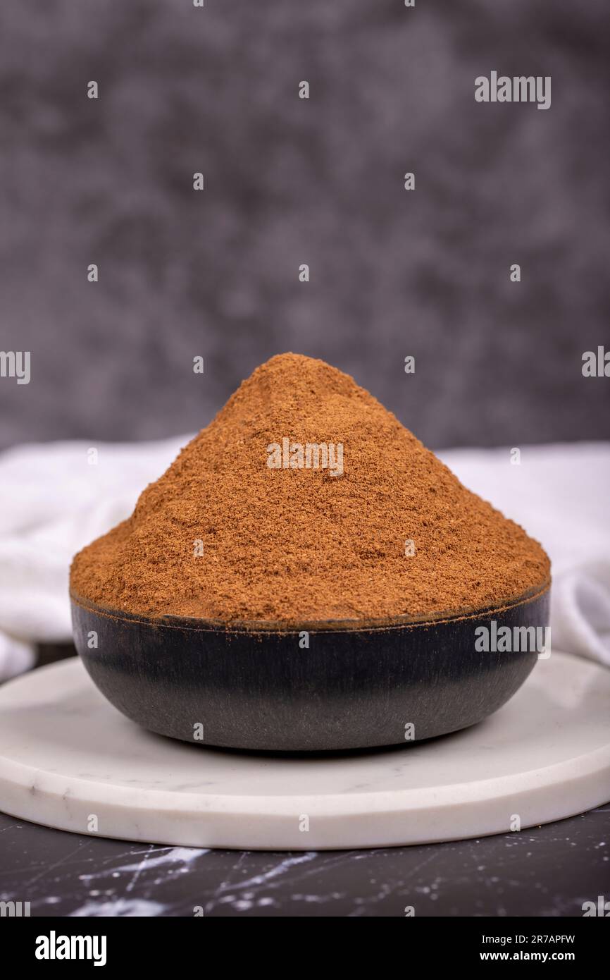 Cinnamon powder on dark background. Powdered dried cinnamon in bowl ...