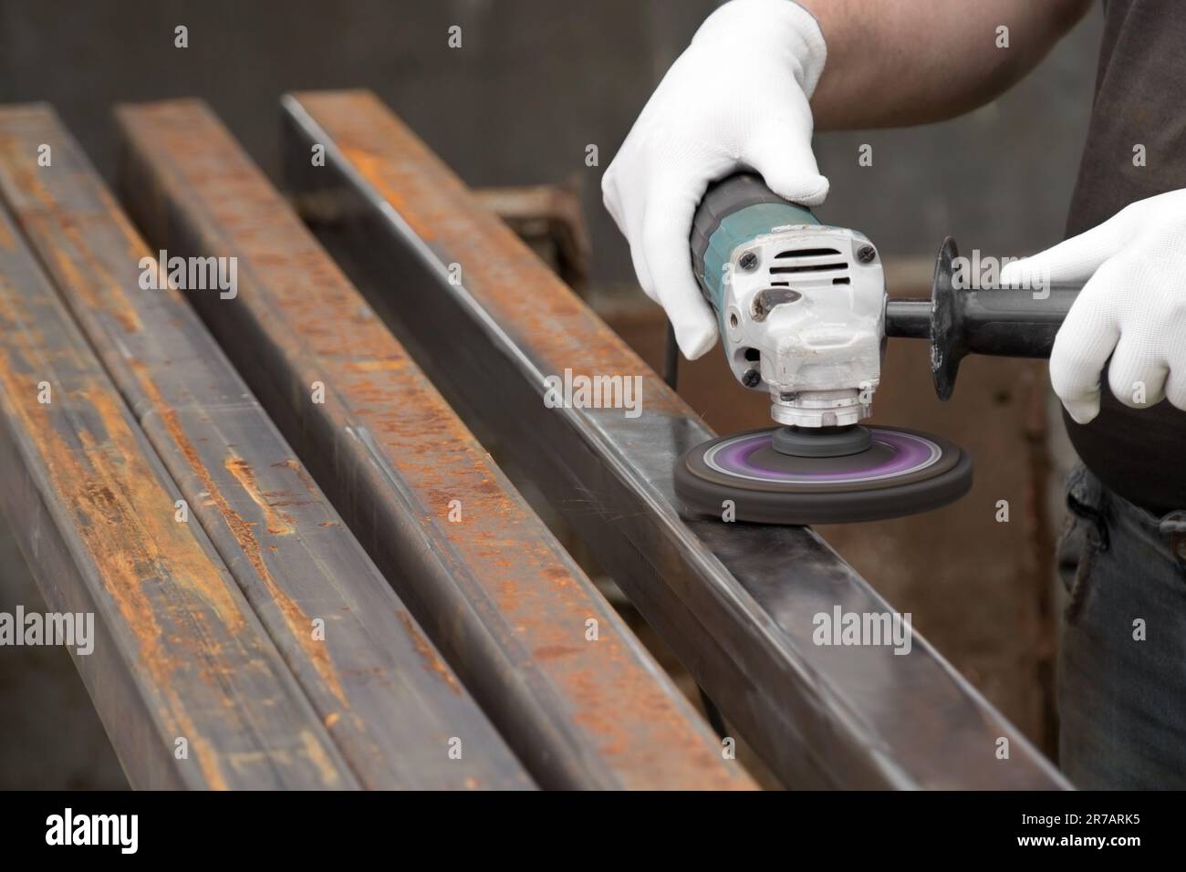 A man working with electric angle grinder tool. Removing rust a metal ...