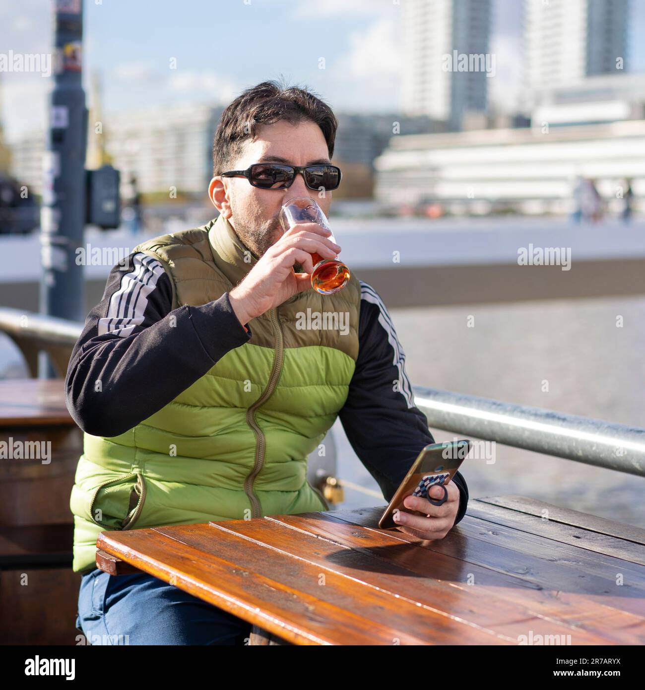 Man drinking a beer while sitting in a bar at the harbor Stock Photo ...