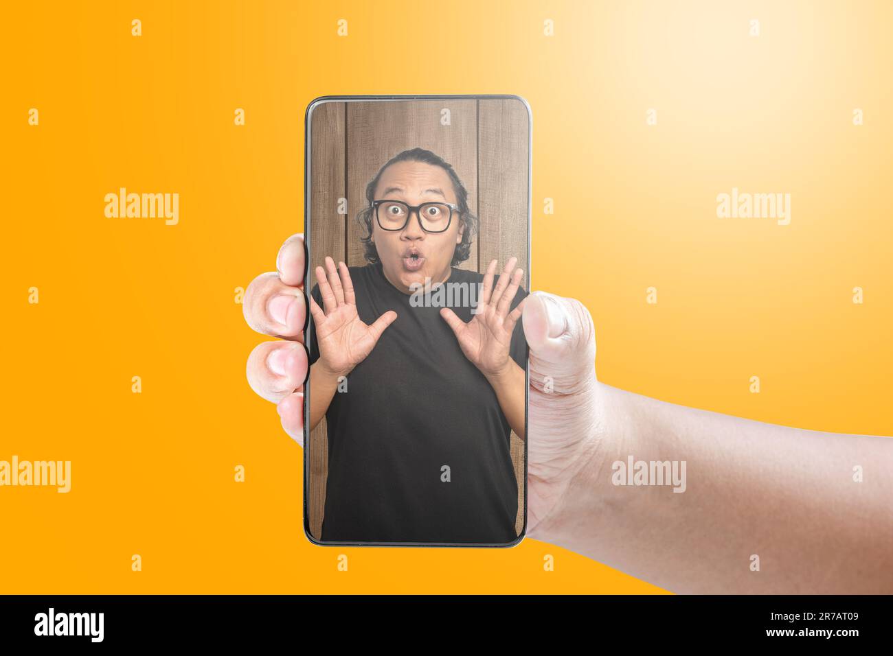 Portrait of an Asian man with a happy facial expression on the mobile ...